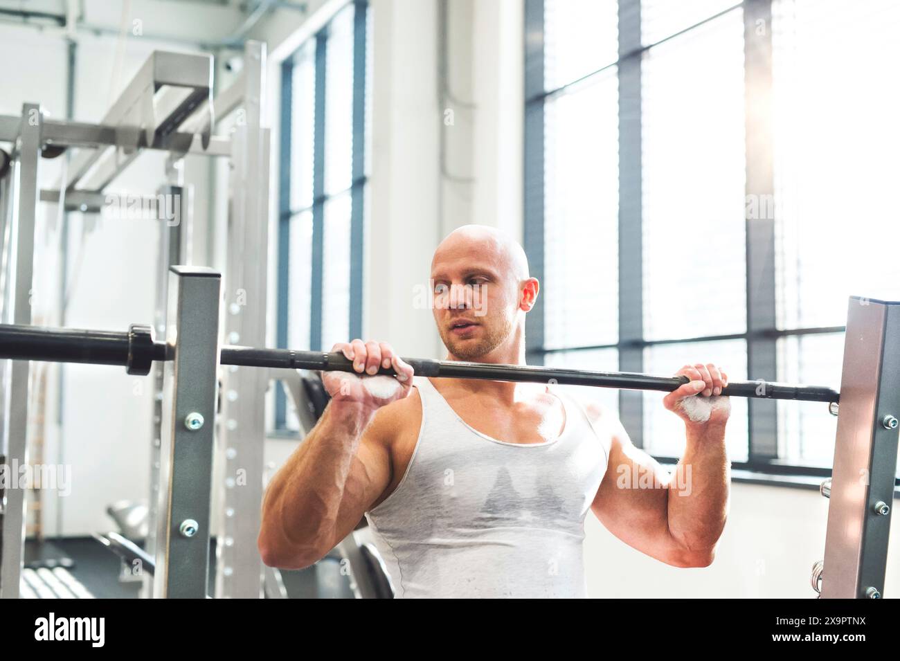 Strong man performing overhead squat pressing barbell up. Routine ...