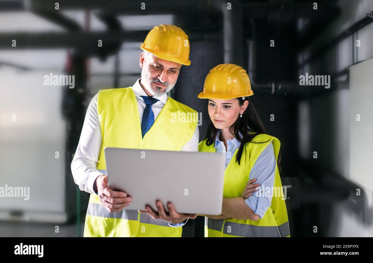 Two project managers standing in modern industrial factory ...