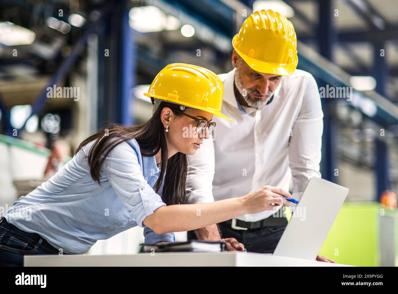 Two project managers standing in modern industrial factory ...