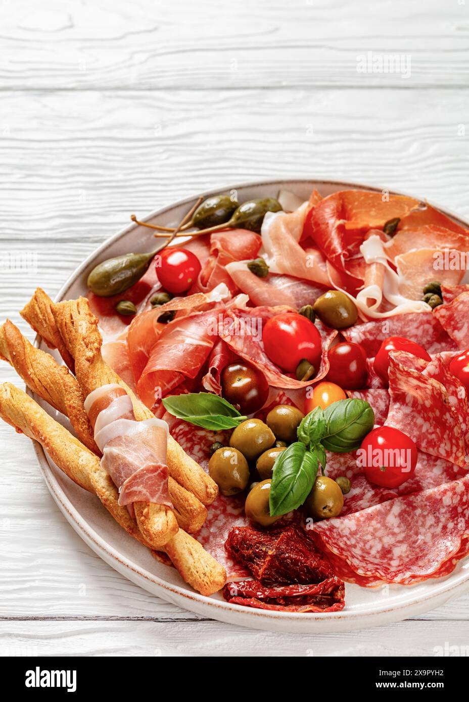 italian antipasto platter of salami slices, parma ham, grissini ...