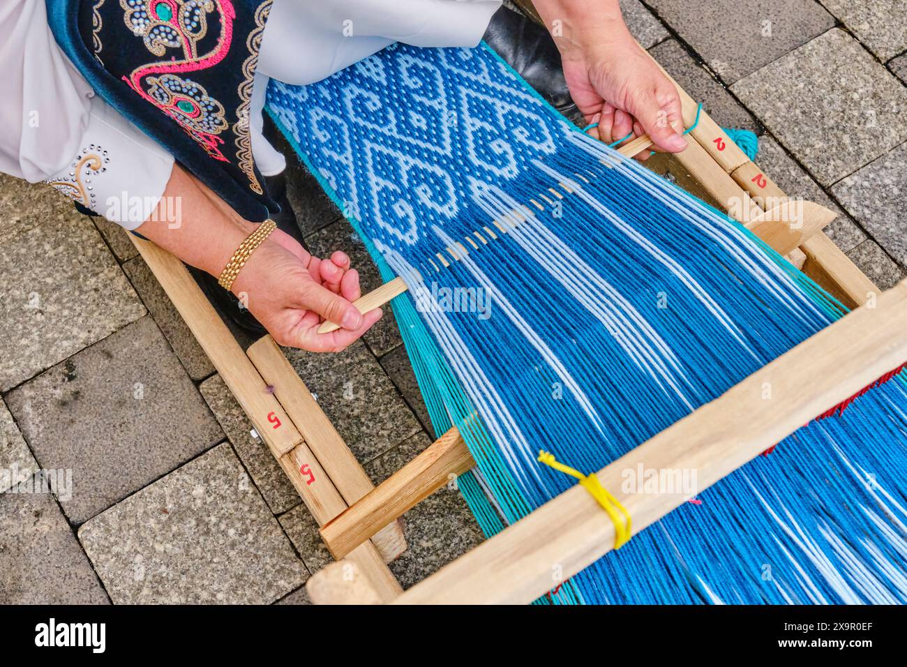 Female hands weaving cloth from wool threads with traditional colorful ...