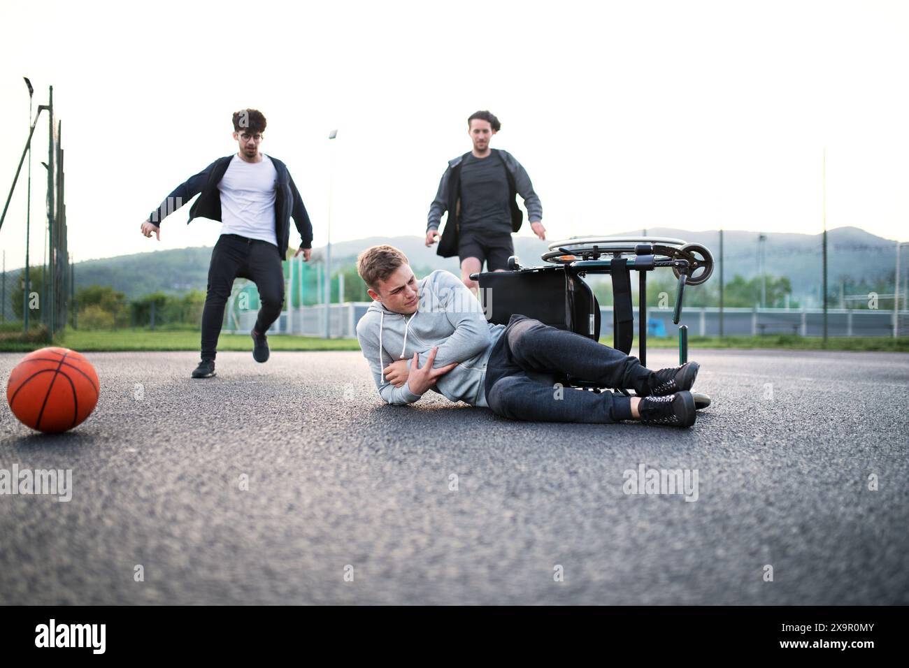 Young disabled man fall off wheelchair, fiends helping to sit back ...