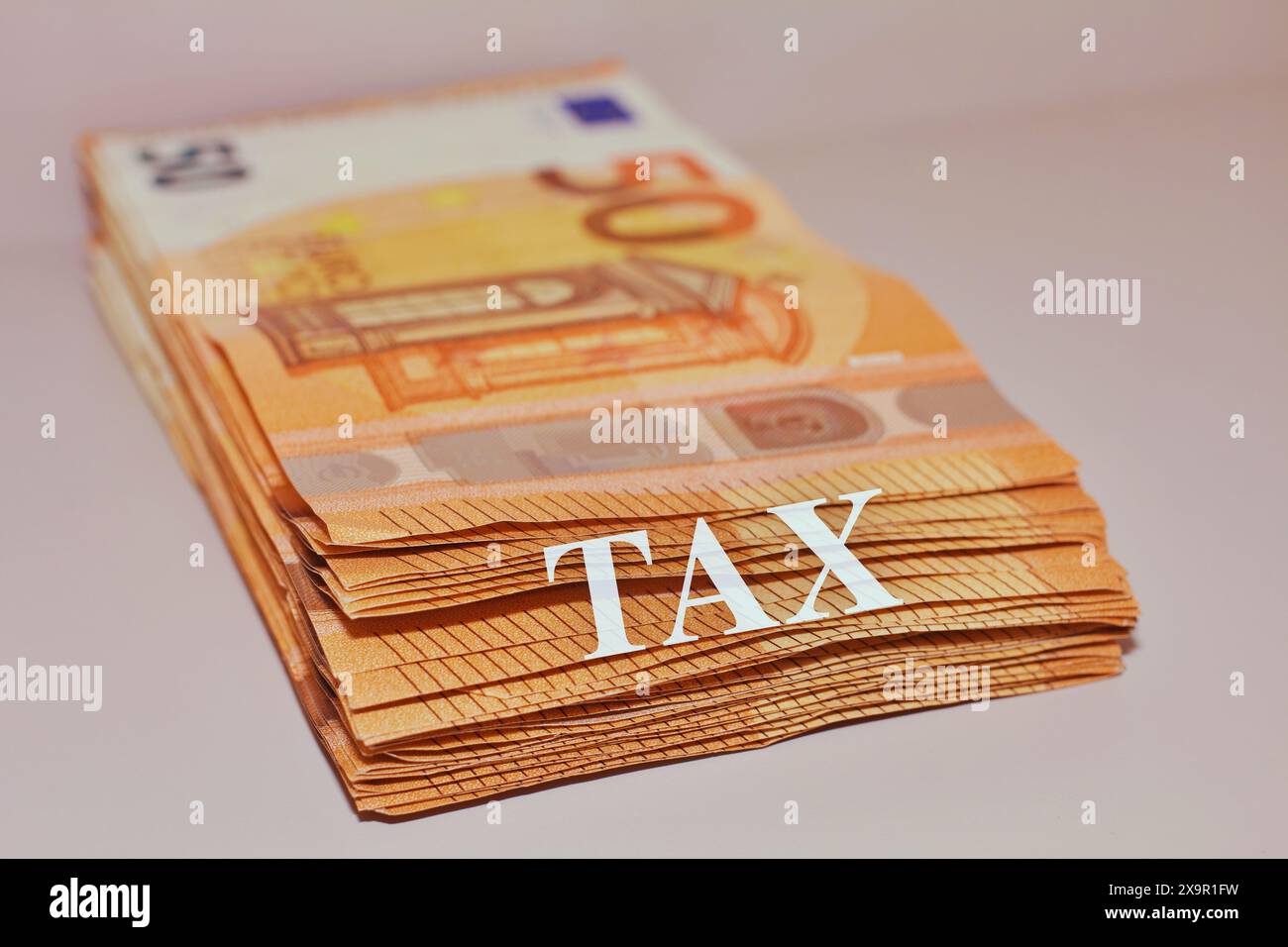 Stack of Euro banknotes with the text "Tax Stock Photo - Alamy