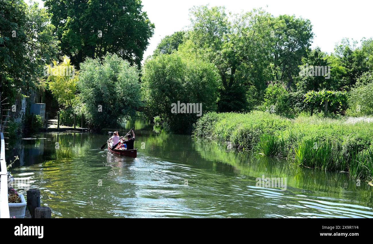river stour in fordwich village showing canoes with men sitting on the ...