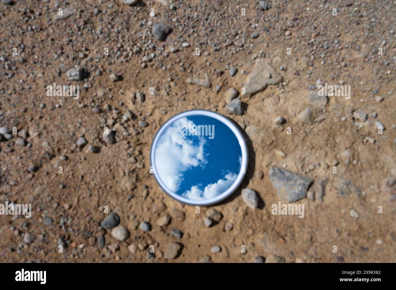 Blue sky reflected in the mirror breaking up on dry soils. Climate ...