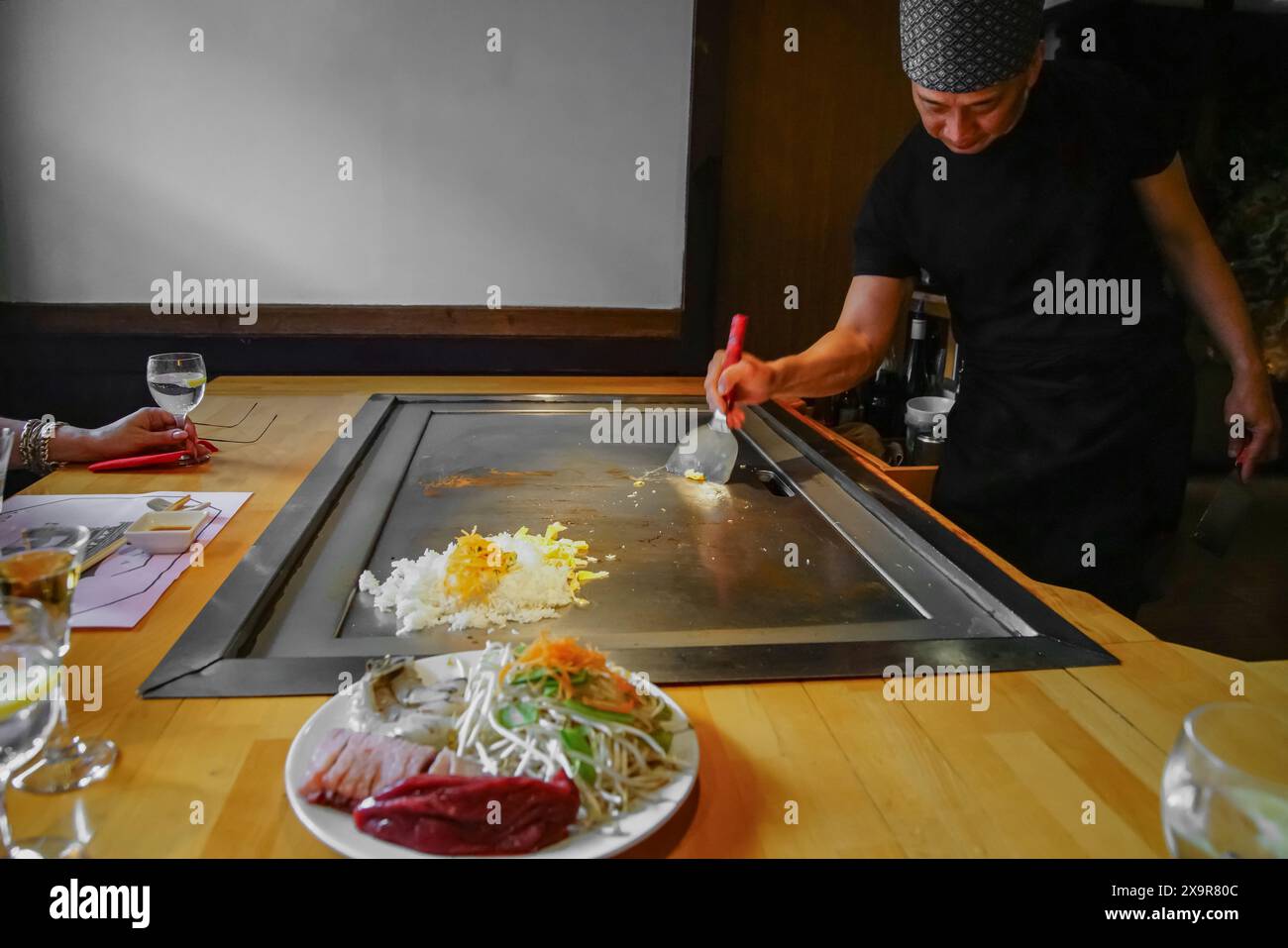 Berlin, Germany. 08. 16. 2023 chef's hands with spatula over teppanyaki ...