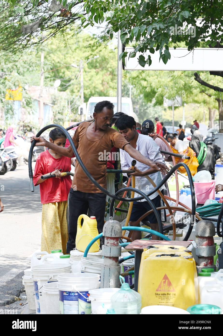NEW DELHI, INDIA - JUNE 2: Residents of a JJ Cluster get drinking water ...