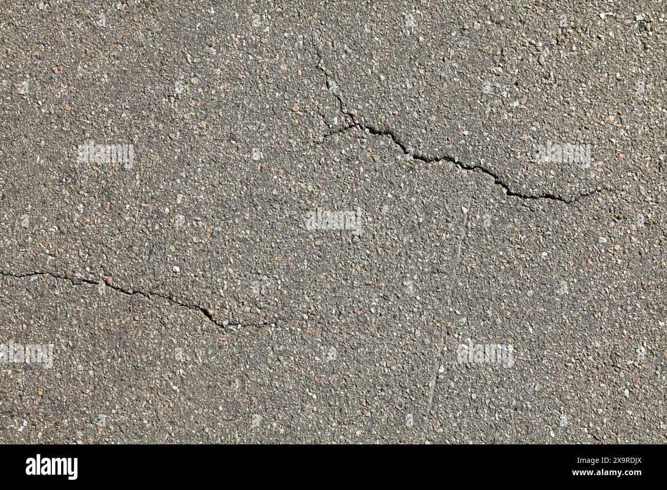 Grey road backdrop and texture. Asphalt surface with cracks in the ...