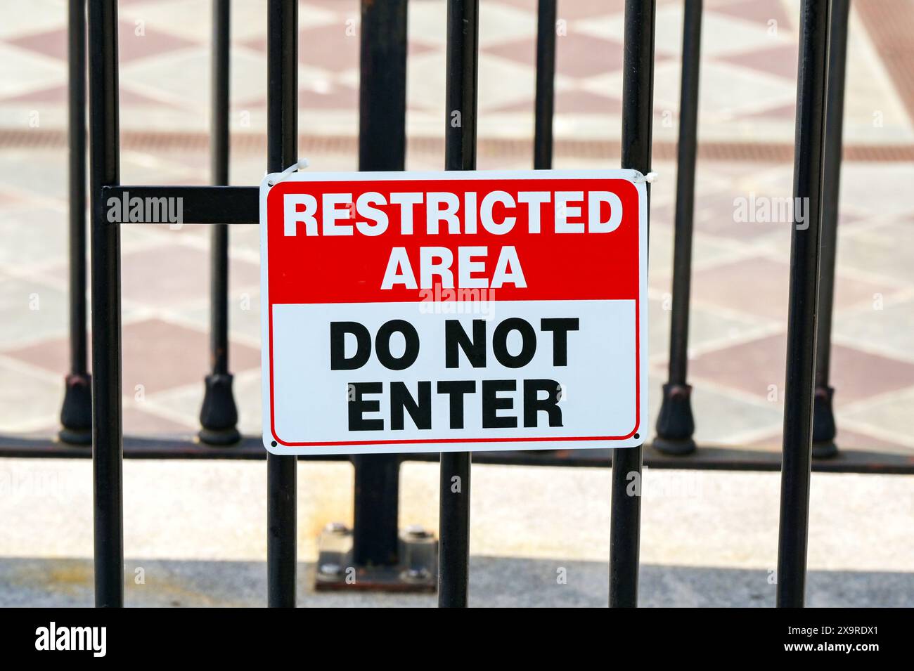 Restricted area sign on a fence with Do Not Enter message. No people ...