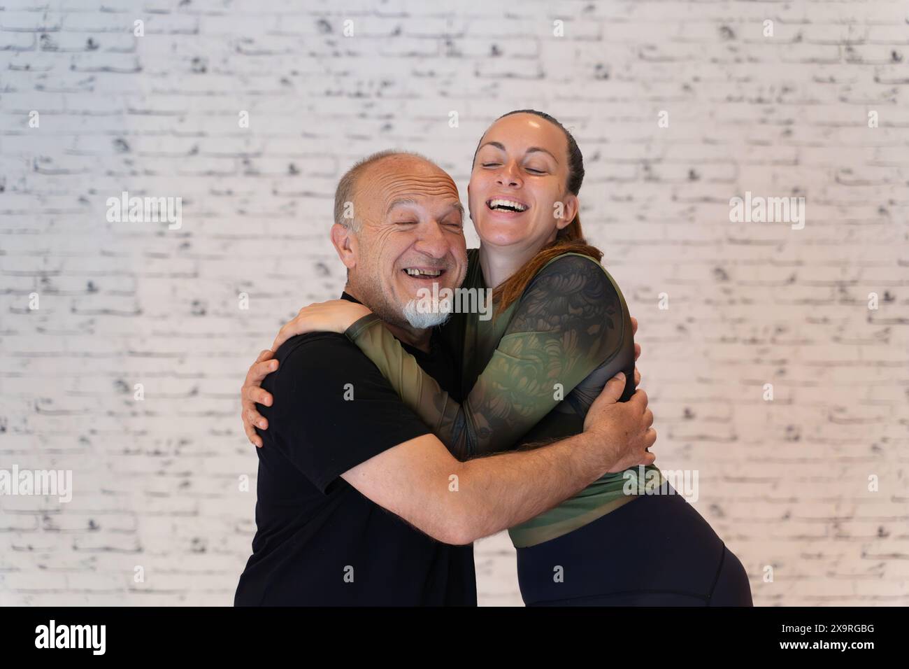 Laughing elderly man in black shirt and young woman in sheer green top ...