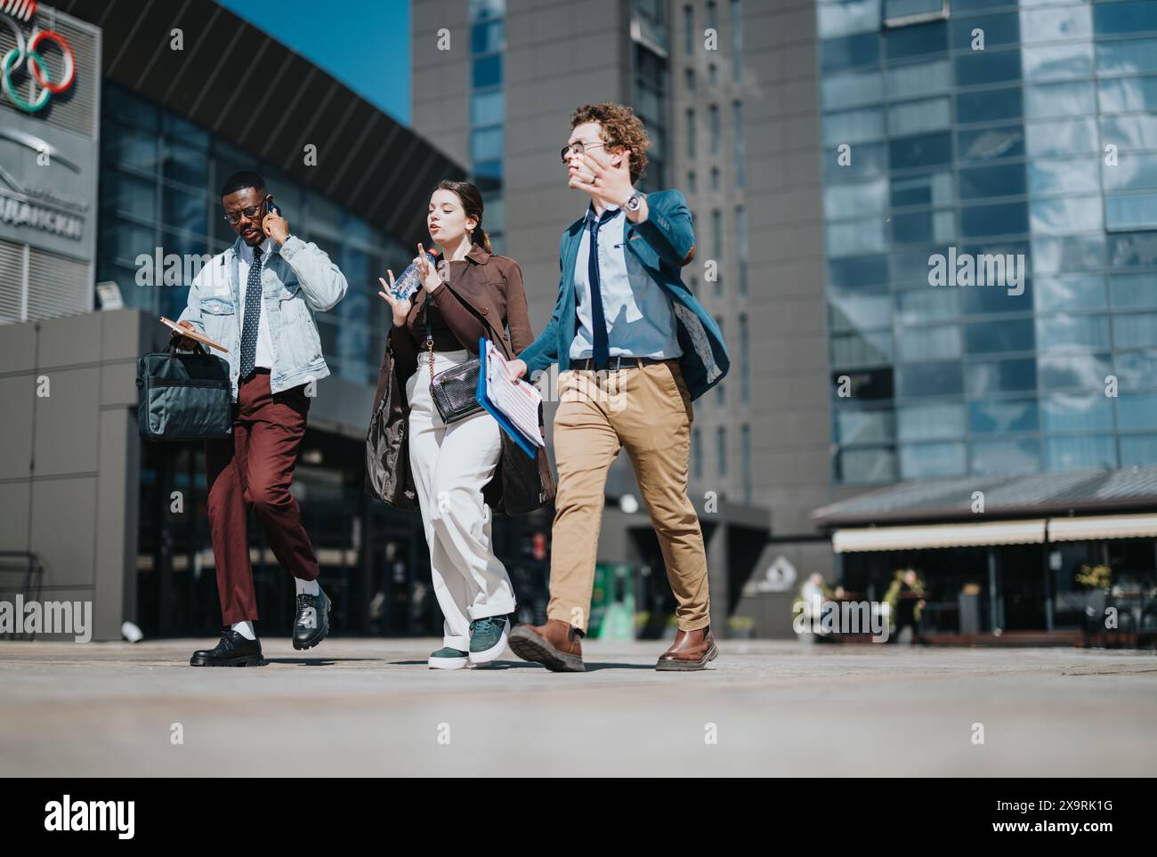 Business colleagues walking together outside a modern building ...
