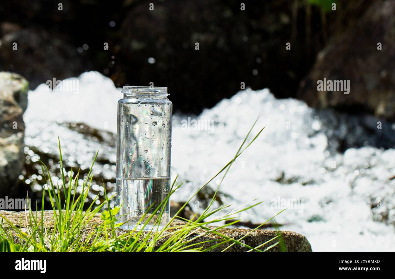 Reusable Water Bottle with clean water on a stone against mountain ...