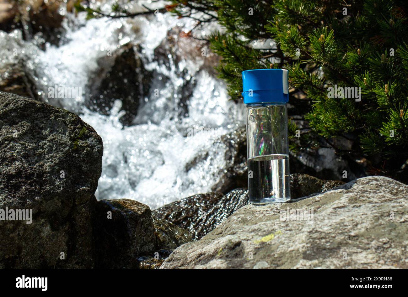 Reusable Water Bottle with clean water on a stone against mountain ...