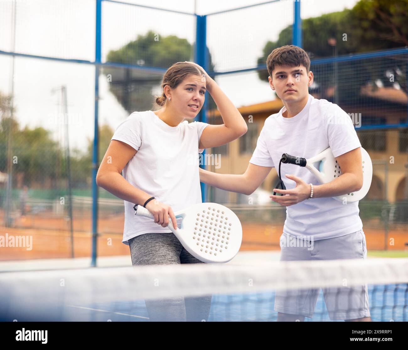 Upset male and female tennis partners after padel match on court ...