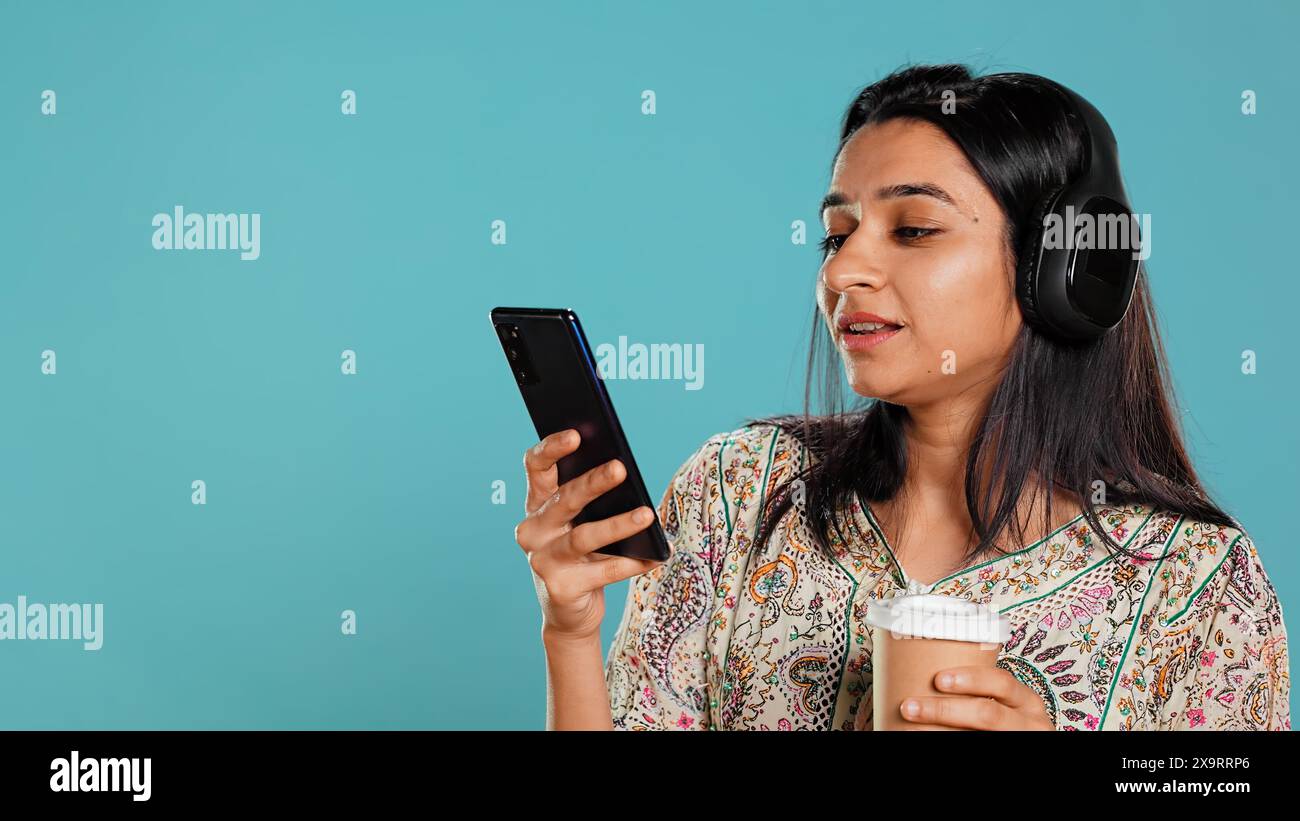 Joyous woman listening music, singing lyrics from phone screen ...