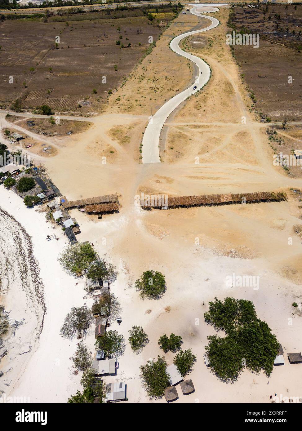 Aerial view of an unfinished road leading towards a sandy beach in ...