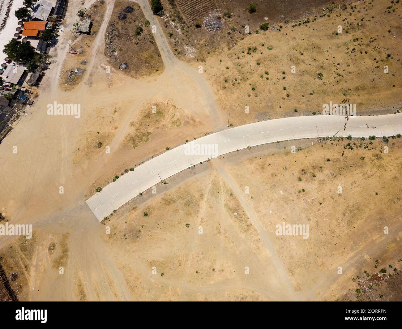 Aerial view of an unfinished road leading towards a sandy beach in ...