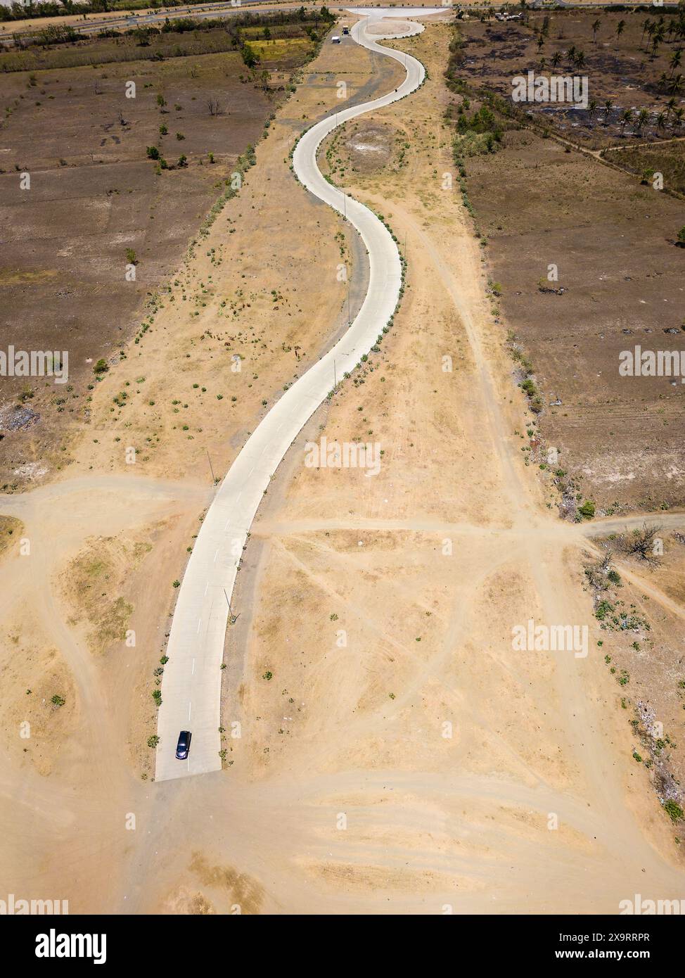 Aerial view of an unfinished road leading towards a sandy beach in ...