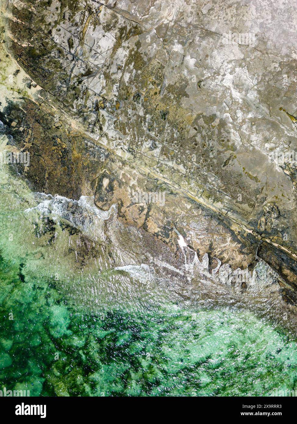 Top down aerial view of waves breaking over a fringing coral reef ...