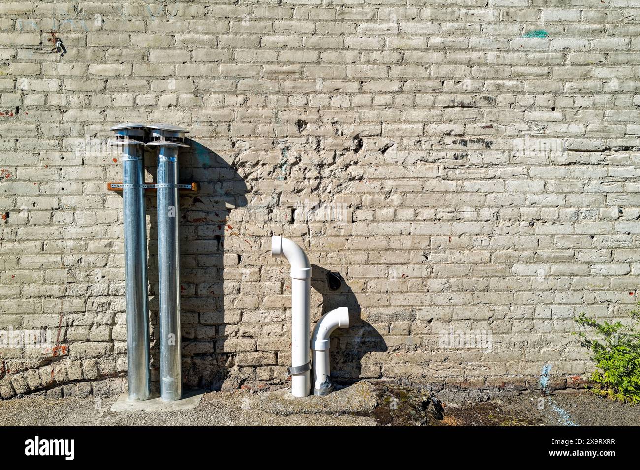 Aluminum and PVC ventilation pipes are installed in the ground next to ...