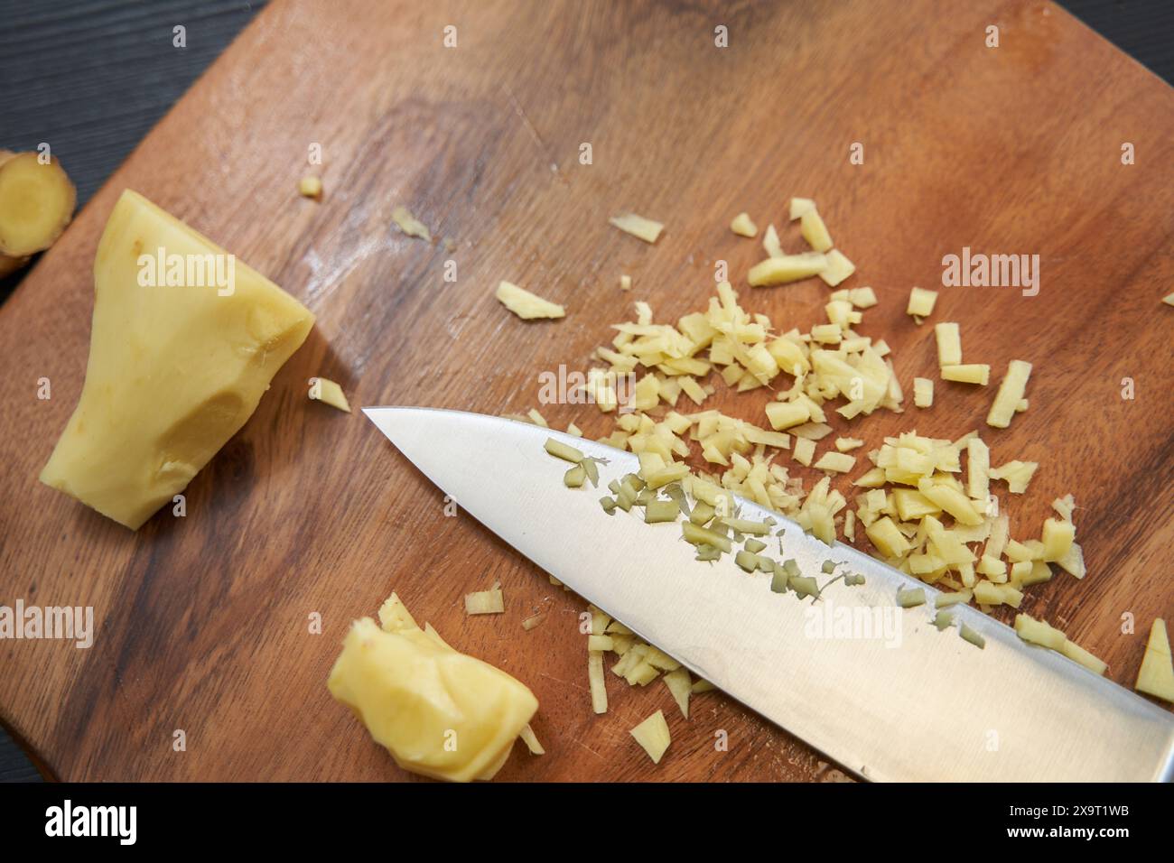 Finely diced ginger root on a wooden rustic board with a knife Stock ...