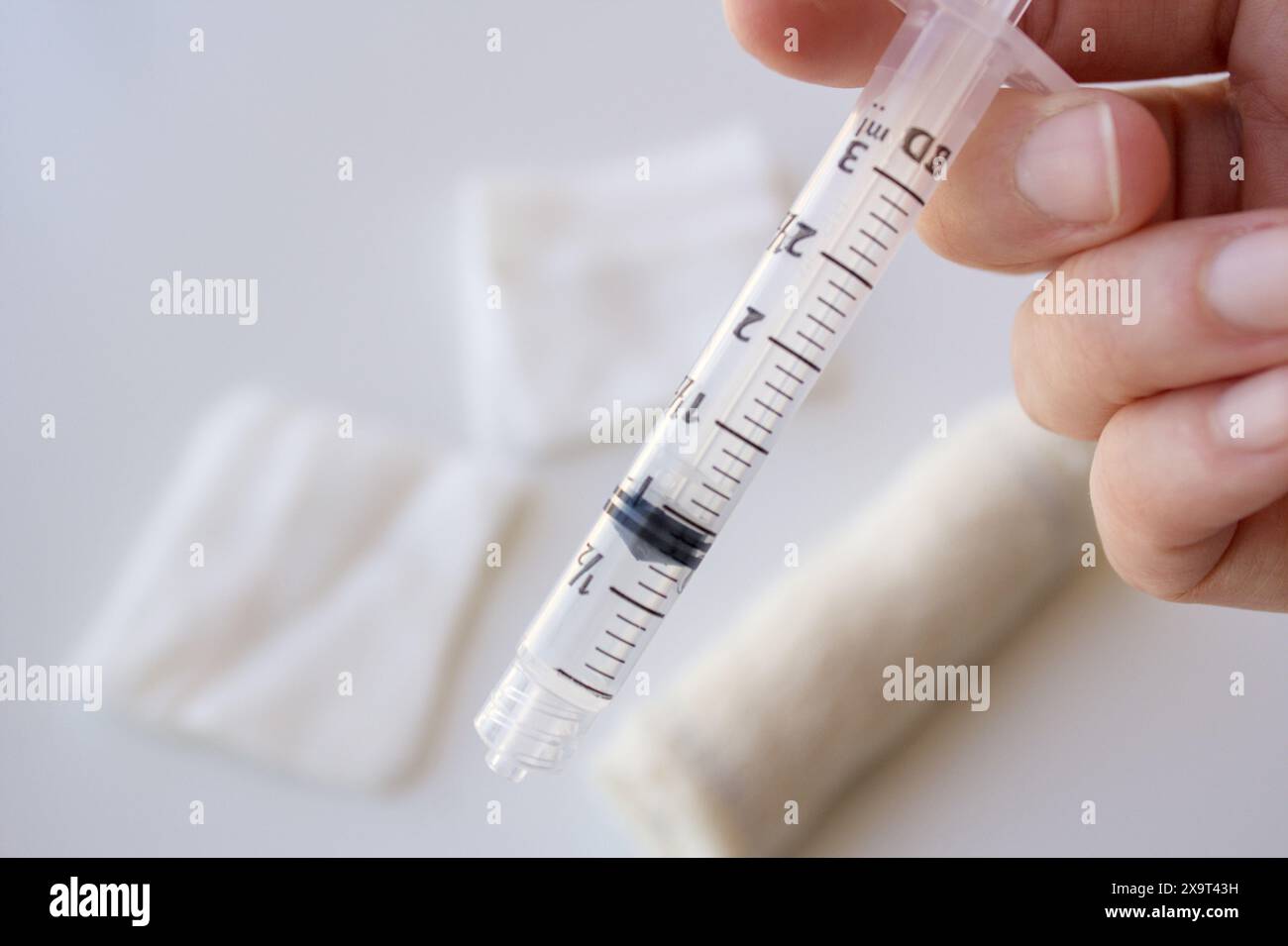 Nurse hand holding an empty syringe over wound dressing bandages on the ...