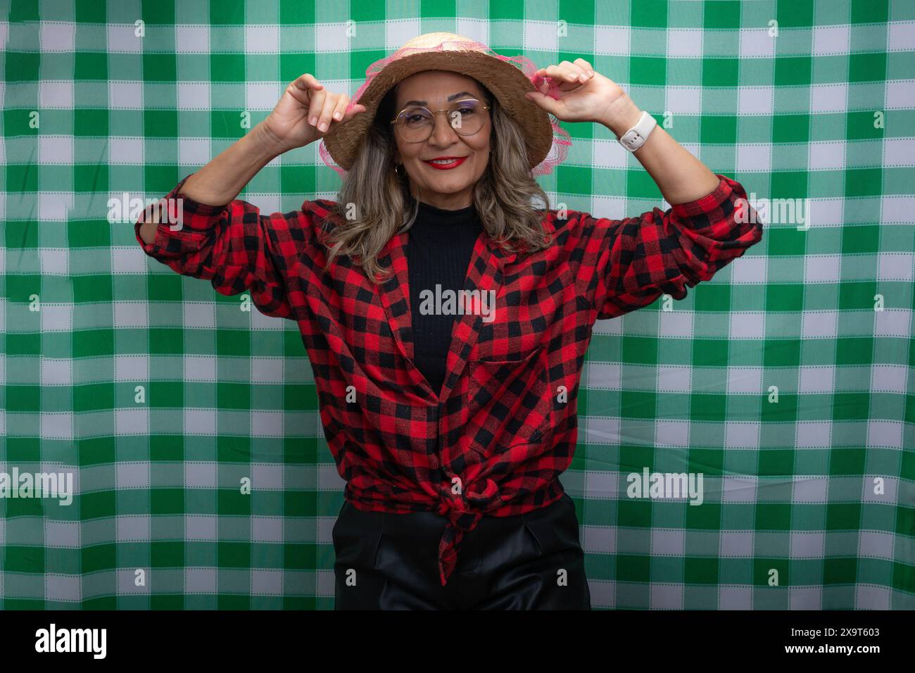 Woman in typical clothes wearing a straw hat dancing and doing poses ...