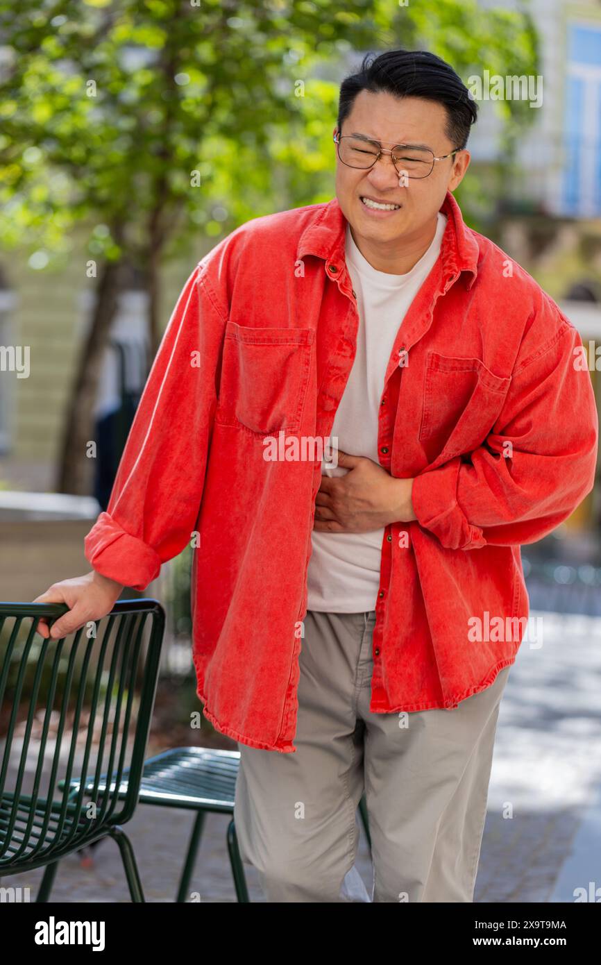 Asian middle-aged man feeling sudden strong abdominal stomach ache ...