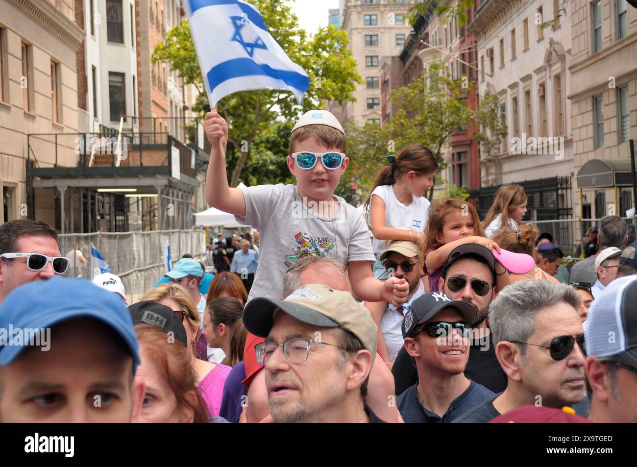 A reveler waves the Israeli flag on Fifth Avenue at the 59th annual ...