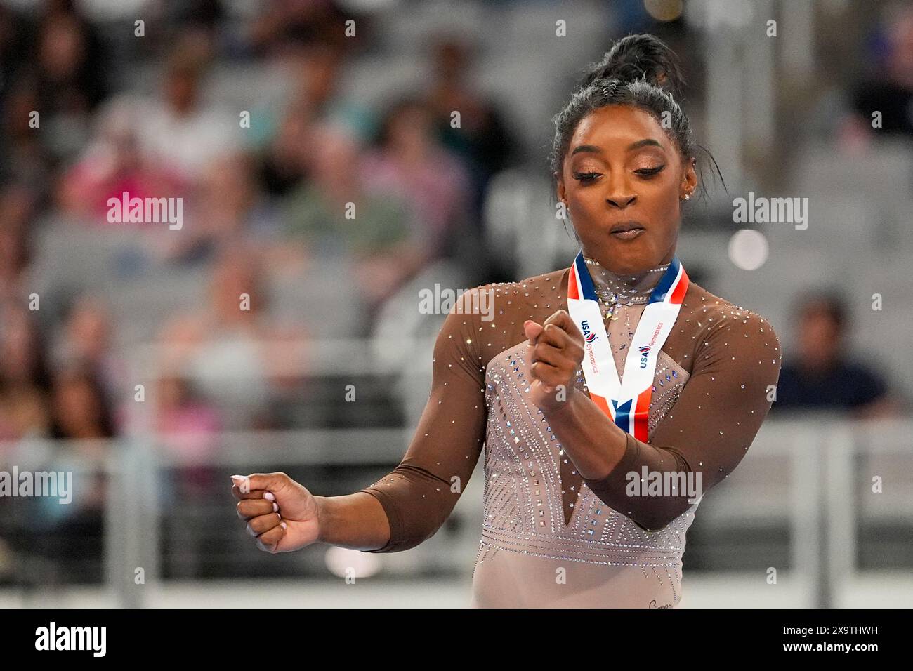 Simone Biles reacts while being honored after wining gold on the uneven ...