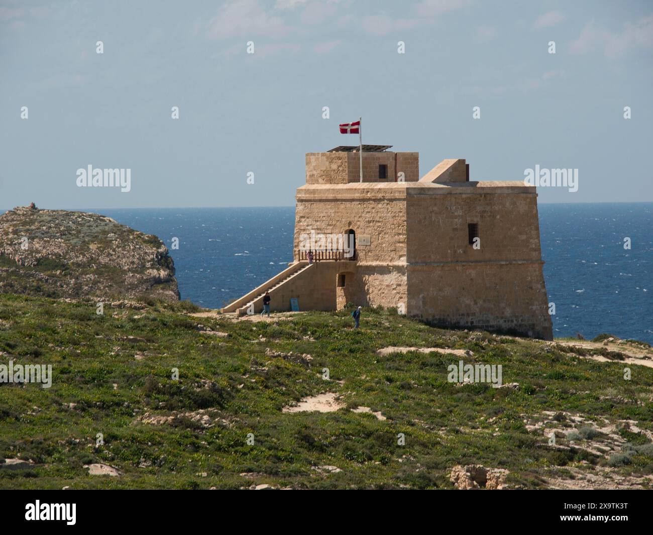Historic tower with flag on the cliffs, surrounded by nature and the ...