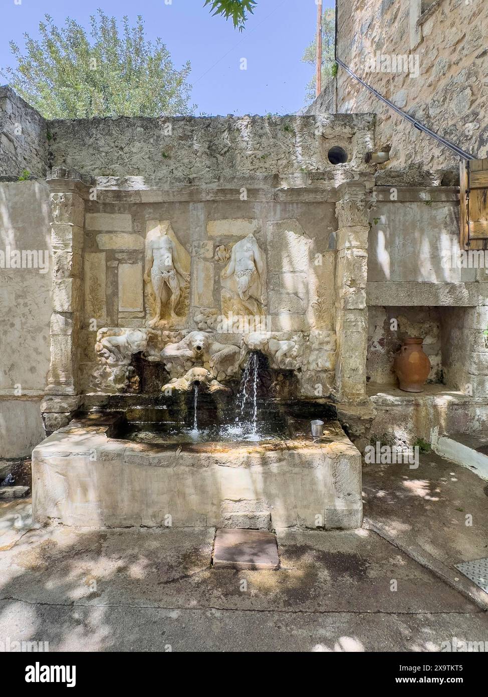 Venetian fountain depicting weathered relief of Adam and Eve in front ...