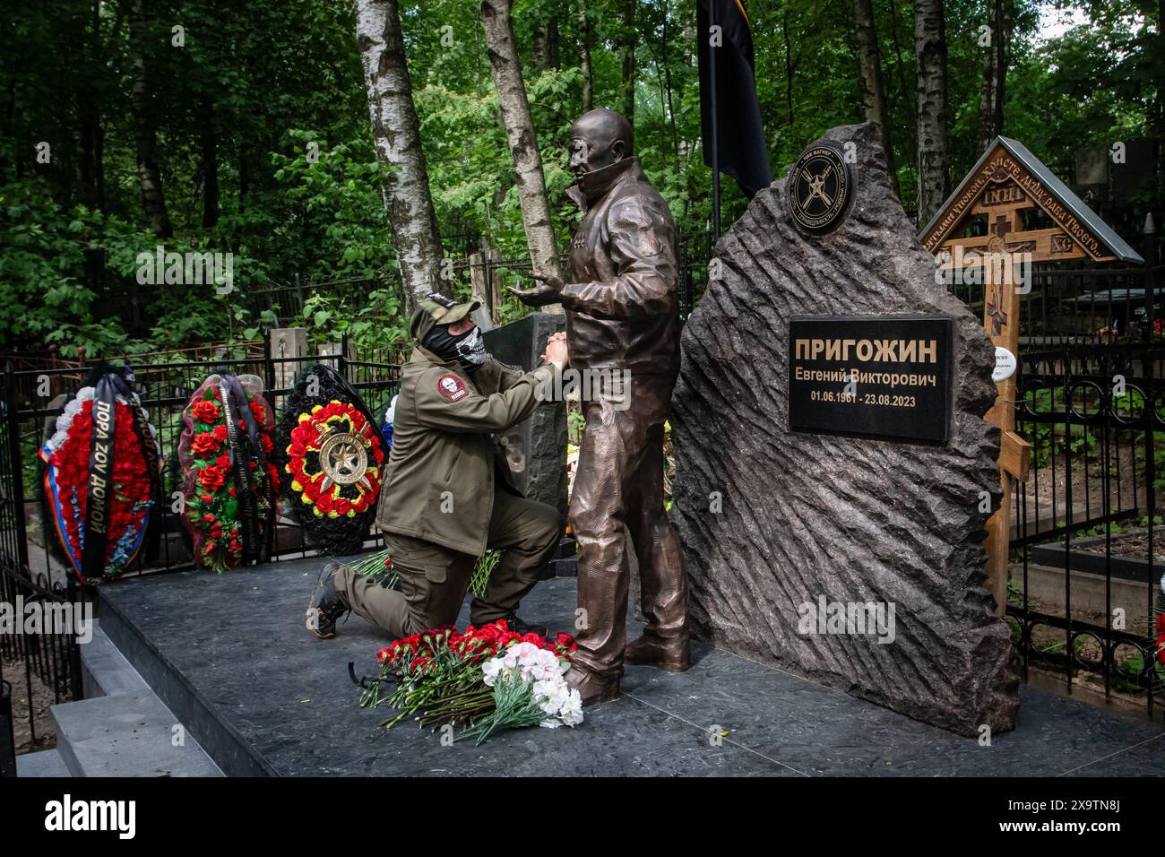 A Wagner PMC fighter kneels and mourns near the installed sculpture of ...