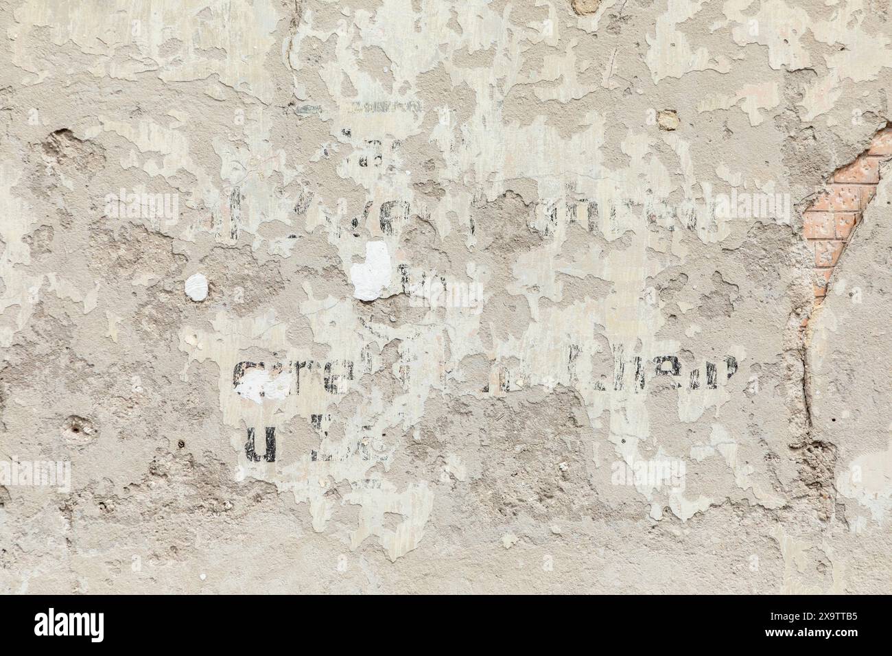 old plaster wall with remains of letters at the wall symbolizing the ...