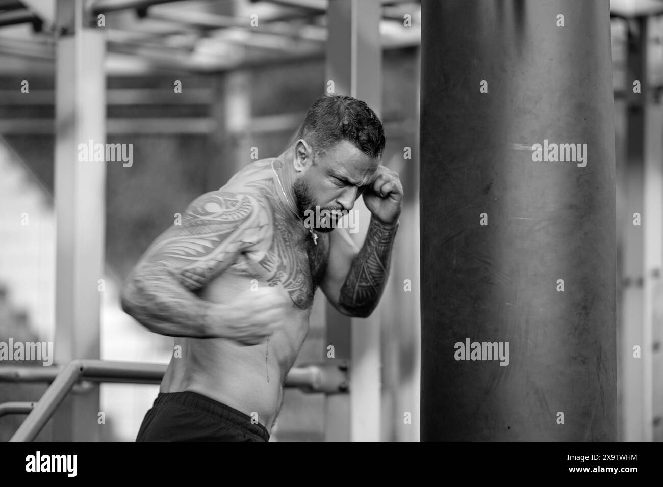 Fighter man punching boxing bag. Fist of muscular man. Close-up of face ...