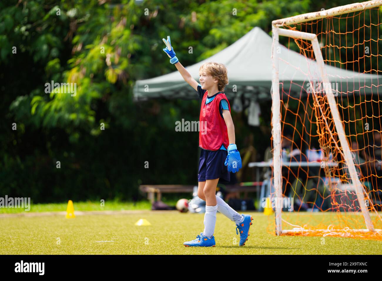 Child playing football. Kids play soccer on outdoor pitch. Little boy ...