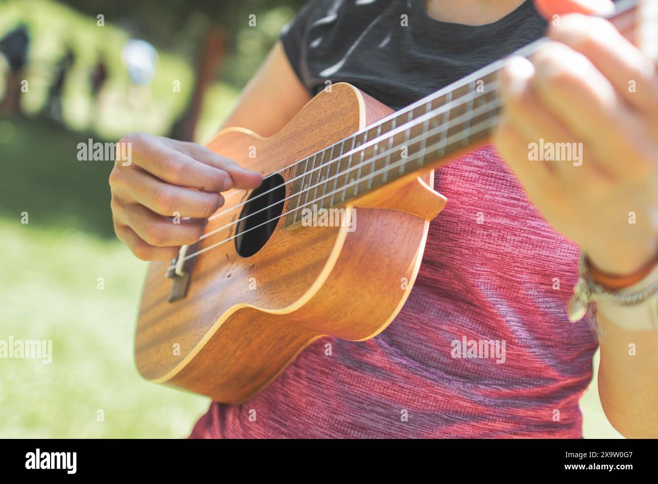 Ukulele played by a girl at a party in a meadow Stock Photo - Alamy