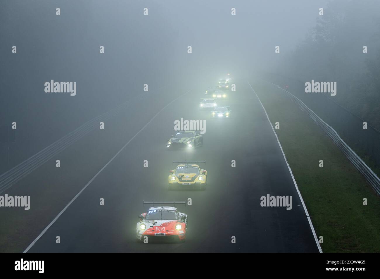 02 June 2024, Rhineland-Palatinate, Nürburg: Racing cars drive through ...
