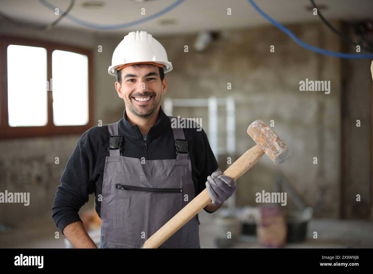Front view portrait of a happy construction worker posing in a house ...