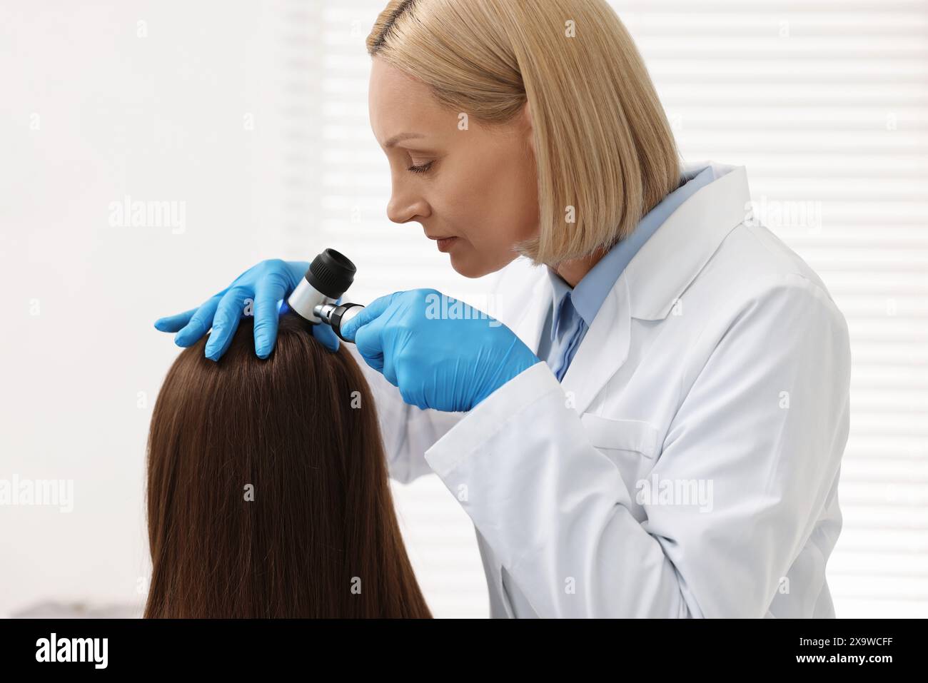 Trichologist with dermatoscope examining patient`s hair in clinic Stock ...
