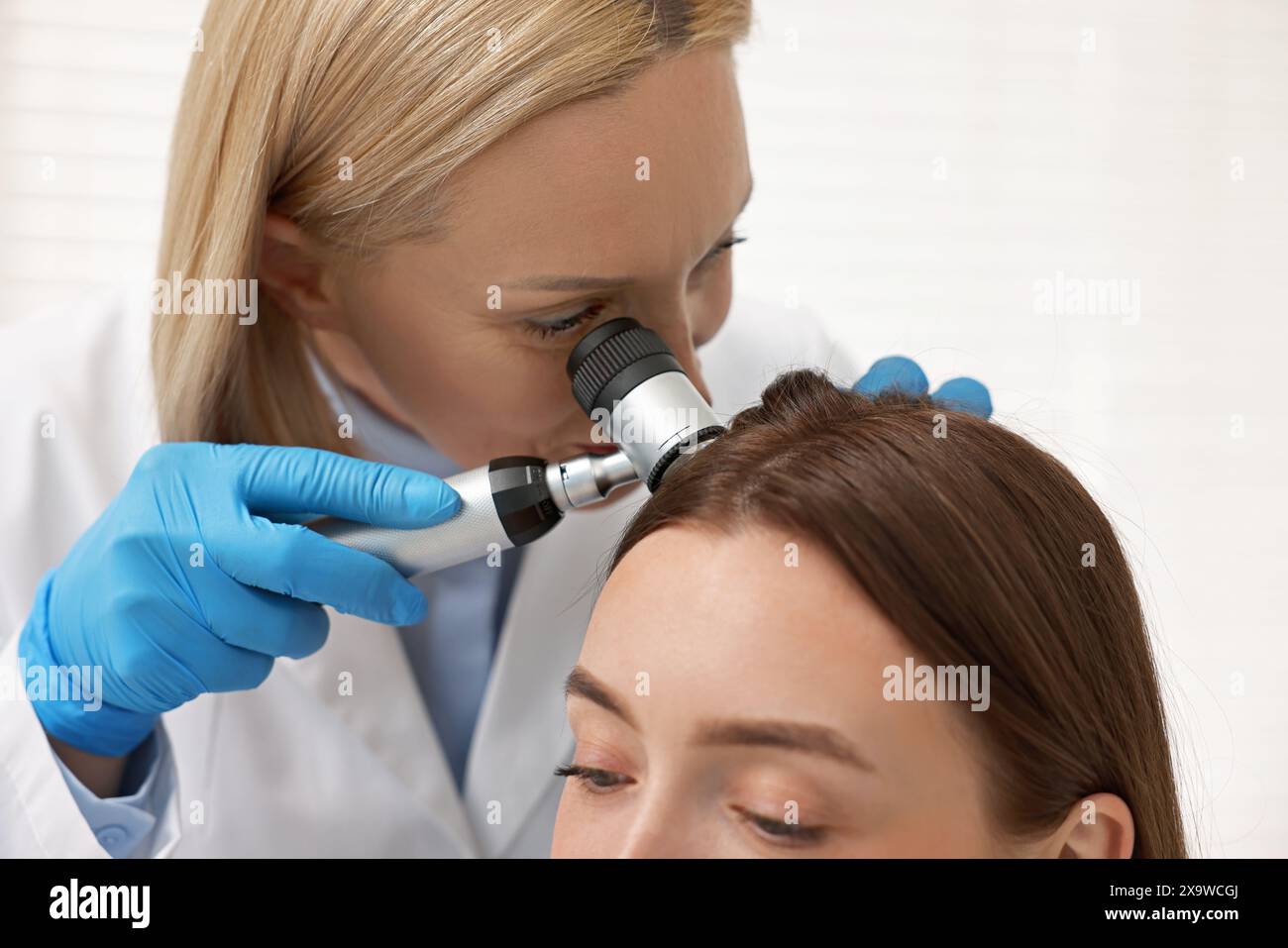 Trichologist with dermatoscope examining patient`s hair in clinic Stock ...