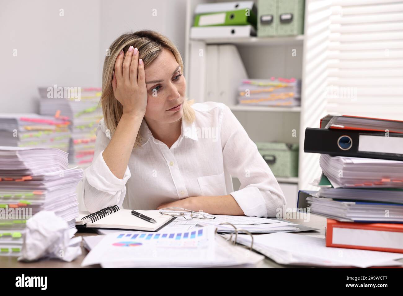 Overwhelmed woman surrounded by documents at workplace in office Stock ...