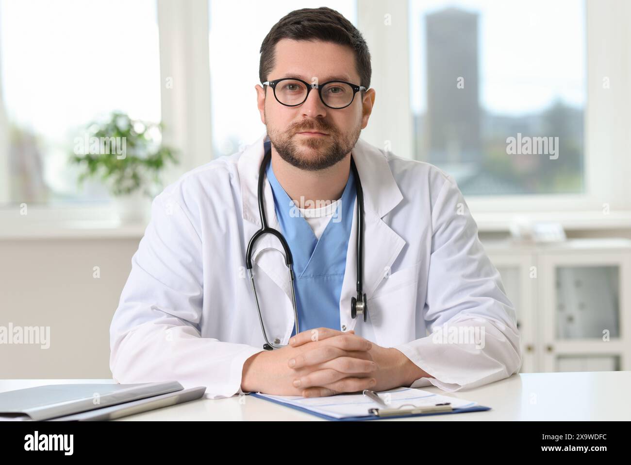 Portrait male doctor table hi-res stock photography and images - Alamy