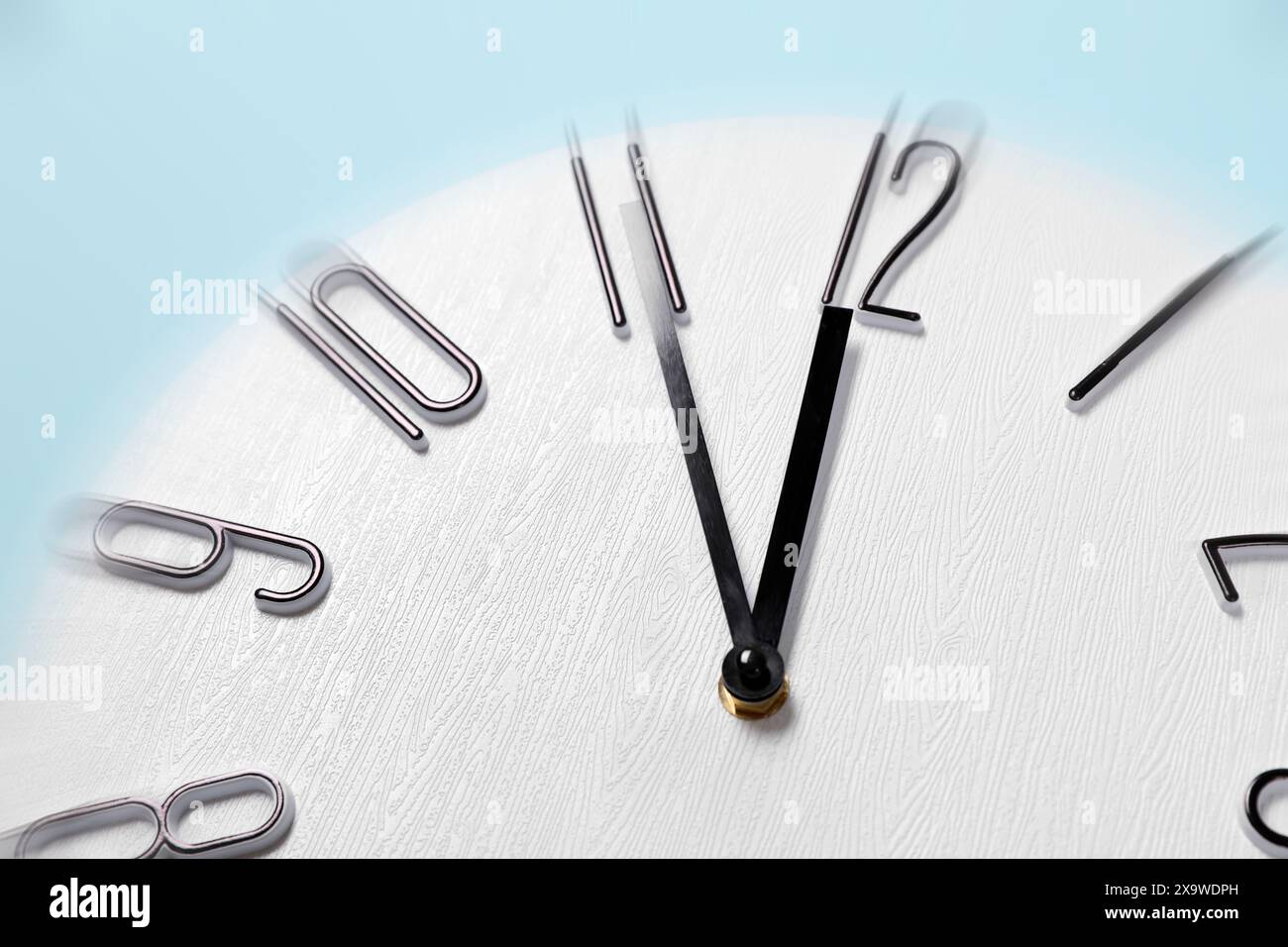 Closeup view of clock on light blue background, motion blur effect ...