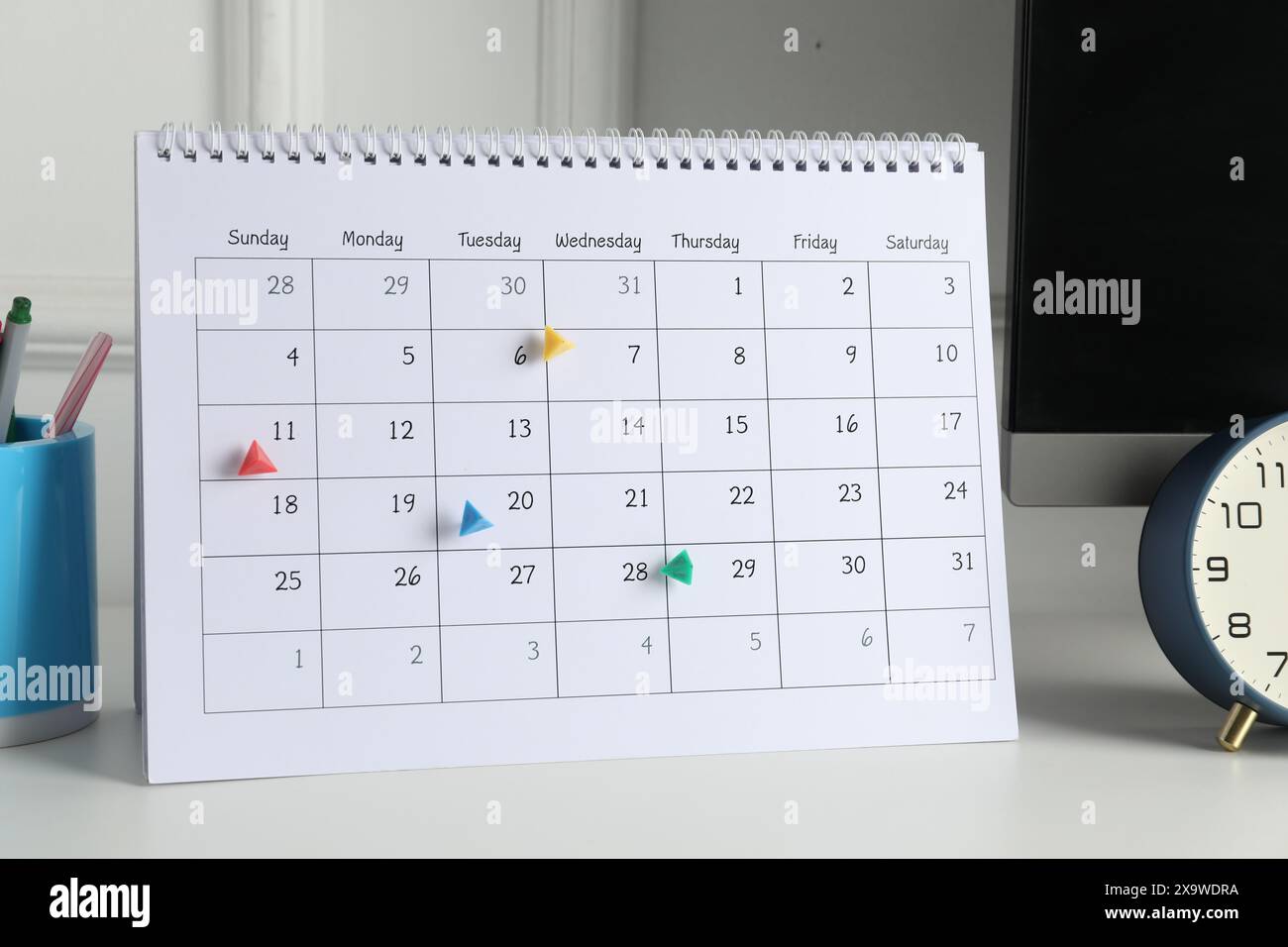 Timetable. Calendar with marked dates, alarm clock and stationery on ...