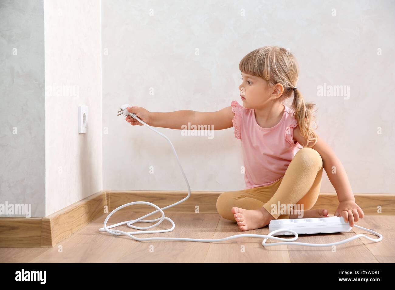 Little child playing with electrical socket and power strip plug at ...