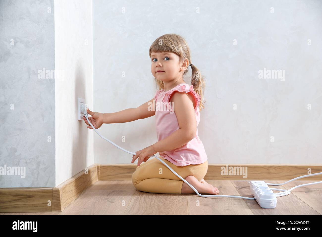 Little child playing with electrical socket and power strip plug at ...