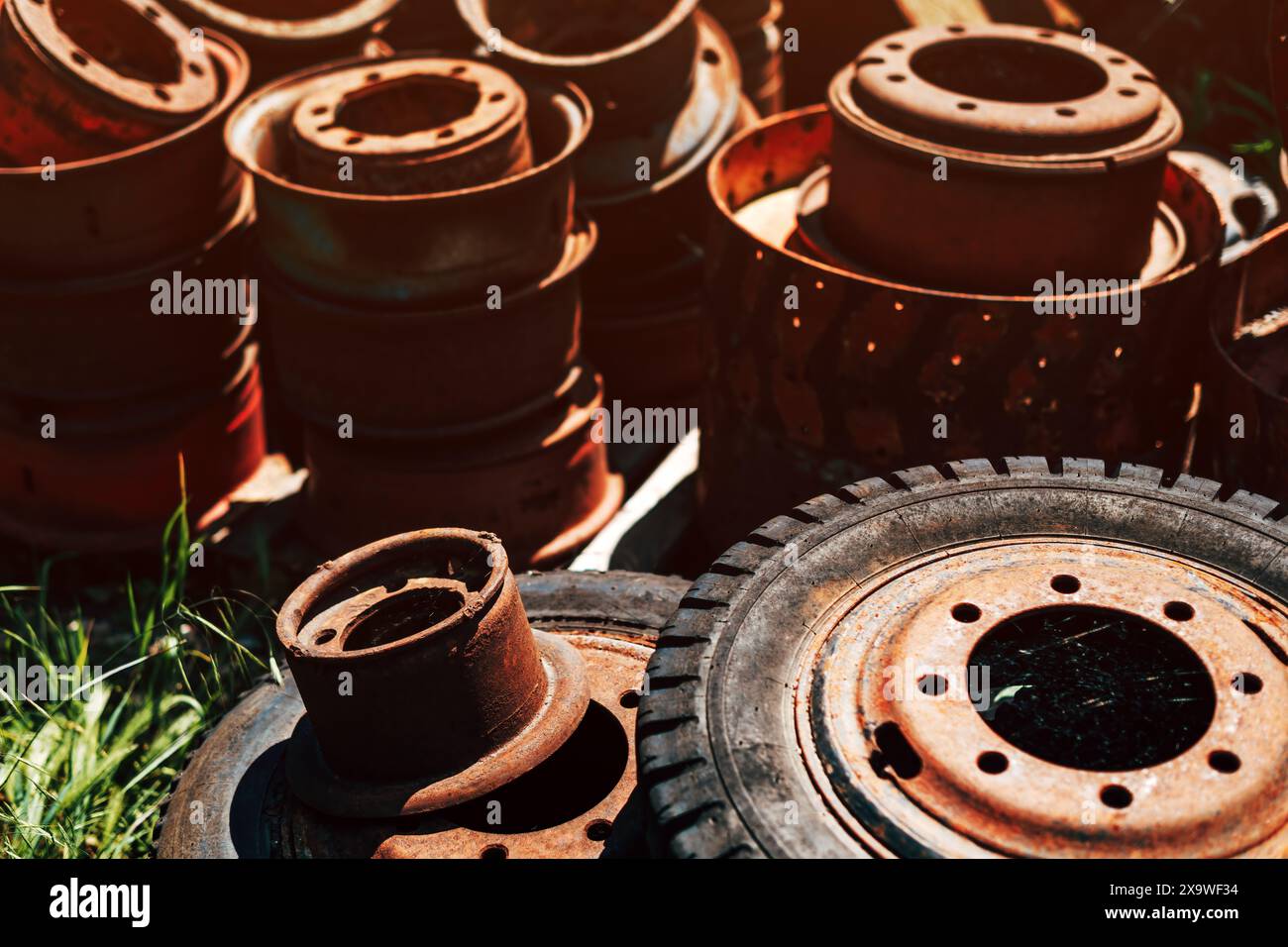 Old worn tires and rusty vehicle wheel rims on dump ground, selective ...