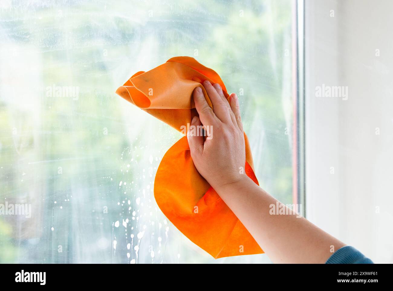 Employee cleaning window pane, wipe with a cloth, dry the water and ...