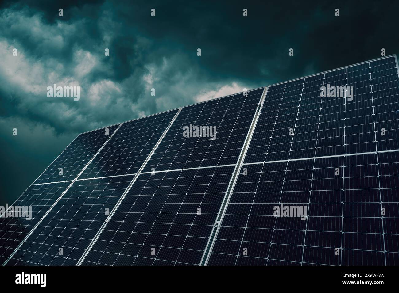 Solar panels photovoltaic cells against dark stormy clouds, selective ...